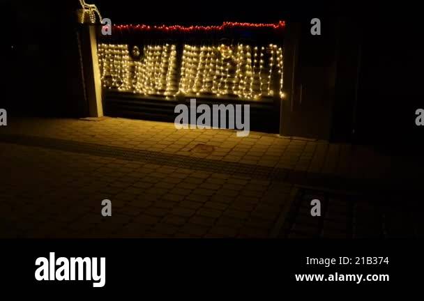 a curtain of string lights billows in the wind at the entrance gate ...