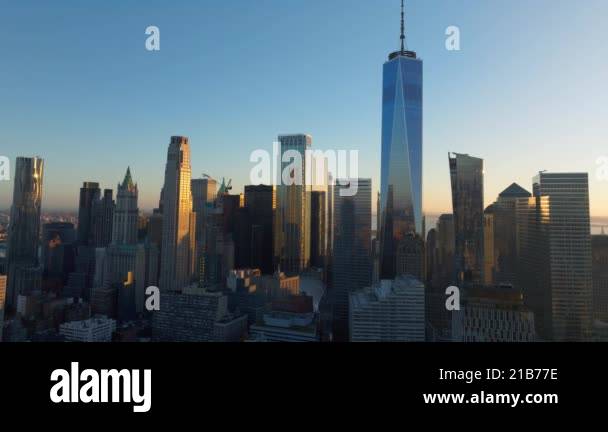 Aerial view of sun rising over the New York City skyline, casting long ...