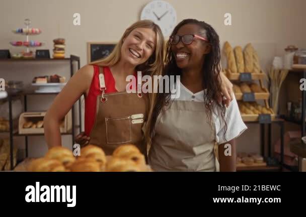 Women bakers smiling together in a bakery with various baked goods on ...