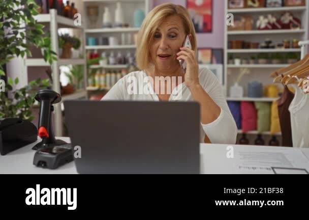 Woman talking on phone in a home decor store, expressing emotions while ...