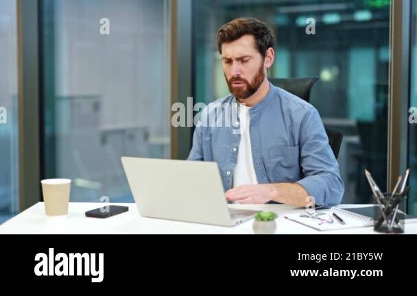 Uncomfortable businessman experiencing back pain while working on ...