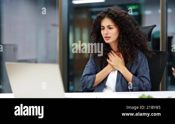 Curly-haired businesswoman in casual clothes sitting at her white ...