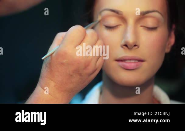 Makeup artist applying eyeshadow for beauty makeup model. Closeup eyes ...