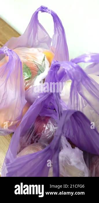 Full plastic grocery bags stand on a wooden bench. Grocery shopping for ...