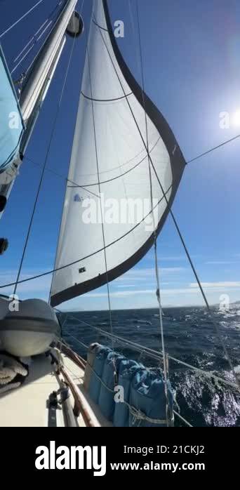 Video footage of a sailboat sailing along in the wind with fore-sail up ...