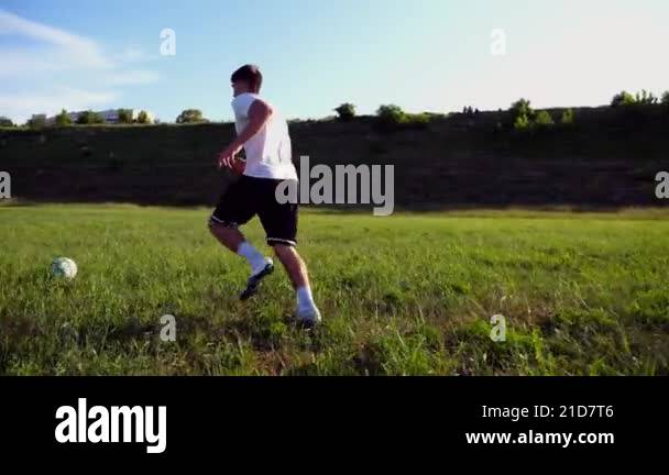 Professional footballer in uniform shows tricks with ball while running ...