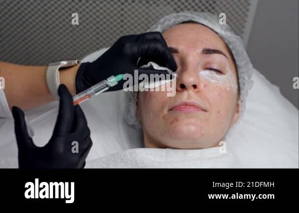 Professional performs cosmetic injection on young adult female client ...