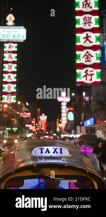 4K Vertical view of taxi sign on tuk tuk roof against night traffic at Bangkok chinatown Stock ...