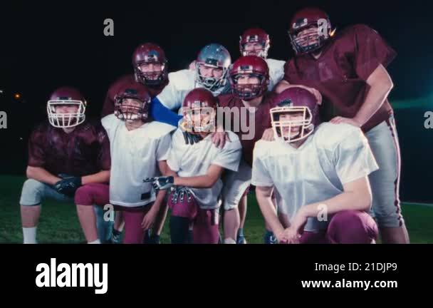 A group of American football players wearing maroon and white uniforms ...