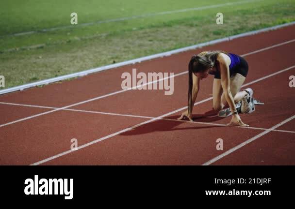 Strong Young Man Starting a Race From Track Starting Blocks Position on ...
