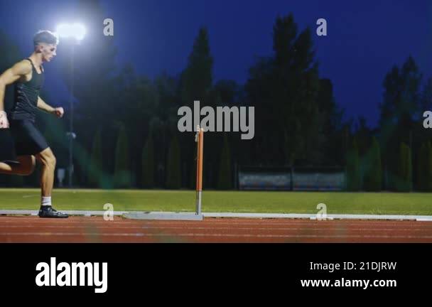 Strong Male Athlete is Running Towards an Obstacle, Hurdling, Jumping ...