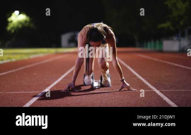 Strong Young Man Starting a Race From Track Starting Blocks Position on ...