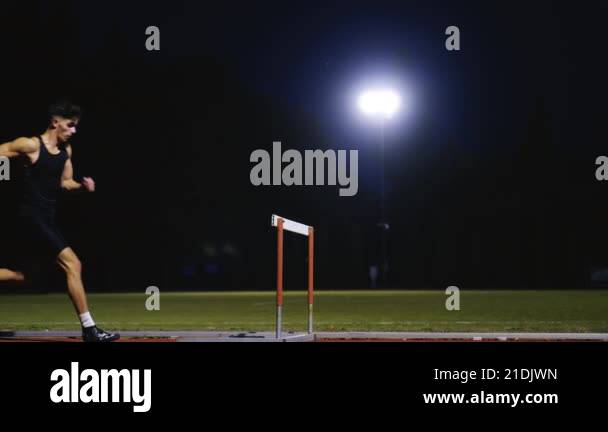 Strong Male Athlete is Running Towards an Obstacle, Hurdling, Jumping ...