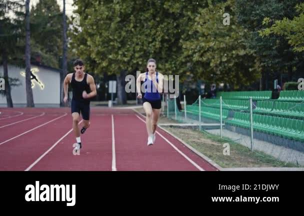 A couple of fit sporty men and woman running while doing exercise on ...