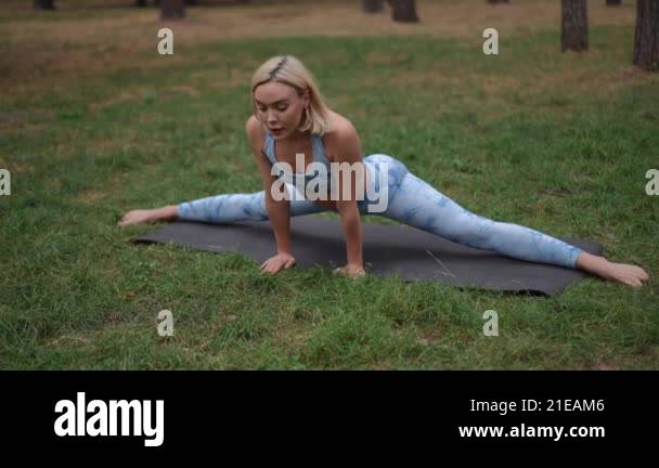 A blonde woman in a stylish blue activewear set practices the Front ...
