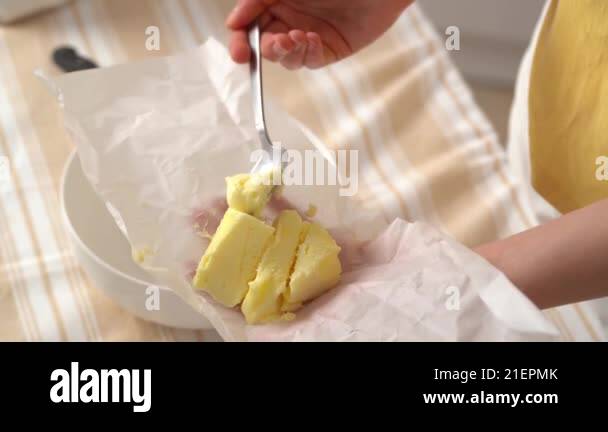 Close-up of a young woman taking spoonful of homemade yellow butter cut ...