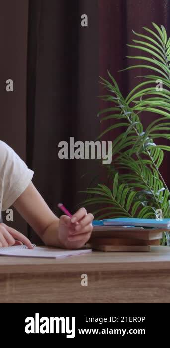 Woman student takes notes while reading online textbook on laptop ...
