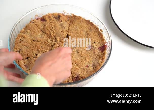 Young woman cuts ready baked grated pie with a knife for further ...