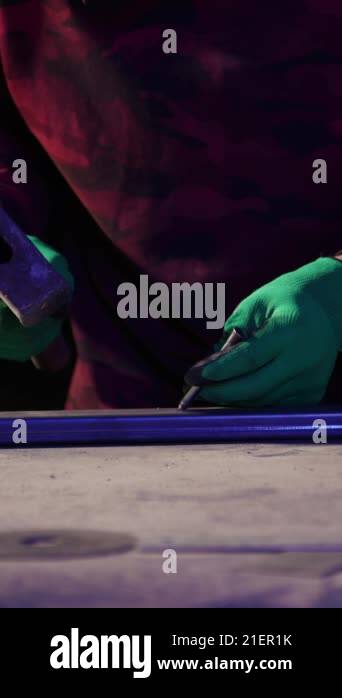 Skilled blacksmith beats large nail into metal profile piece at ...