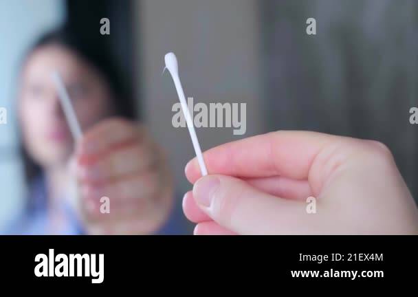 Young woman holding a cotton swab for ear cleaning, ear care for ...