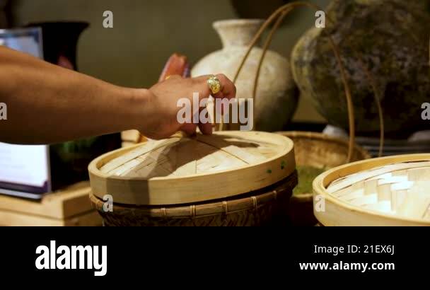 choosing cooked rice in a buffet a mans hand lifts the lids of wicker ...