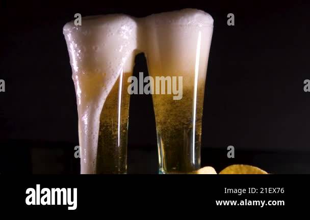 Beer in a beer glass, forming effervescent bubbles and a frothy head ...