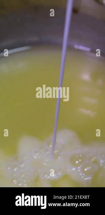 Swirling melting butter in metal saucepan on a flat stovetop hot yellow ...