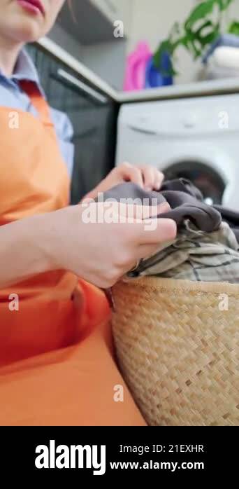 Woman checks clothes after washing to ensure they are cleaned properly ...