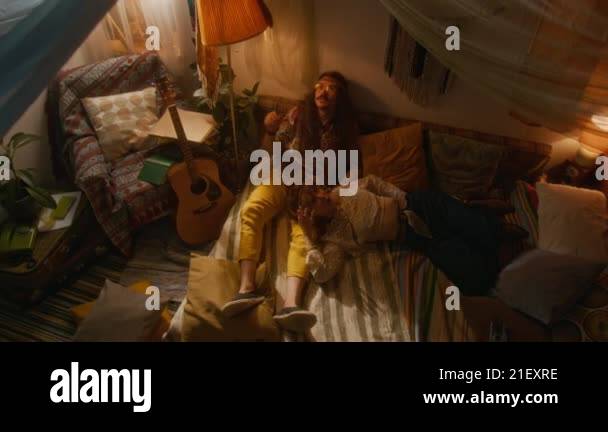 Full top shot of Caucasian hippie couple relaxing together on bed in ...