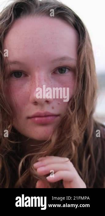 Relaxing on beach emotions of young girl burnt skin red cheeks wet hair ...