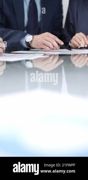 Business people are reviewing contract terms during a meeting ...