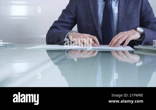 Businessman wearing blue jacket is reviewing important paperwork while ...