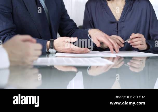 Business partners or lawyers are reviewing contract terms during a ...