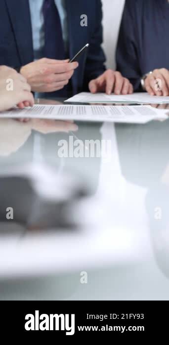 Business people are reviewing contract terms during a meeting ...