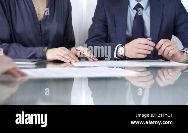 Business partners or lawyers are reviewing contract terms during a ...