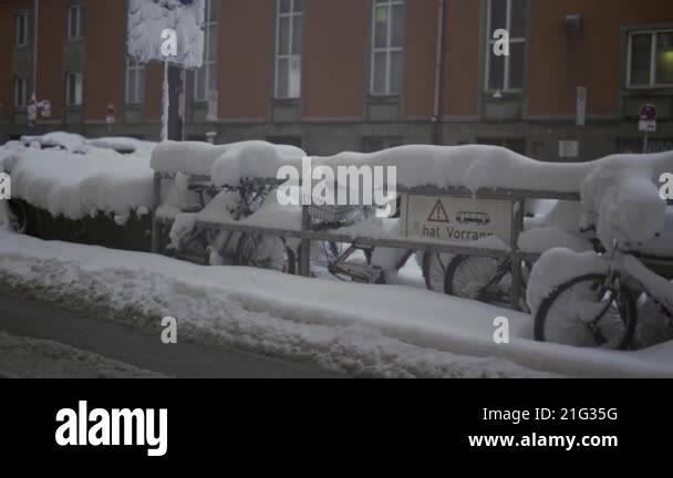 Munich, Germany. Snowfall in Muenchen. Snow covered bicycles in city ...