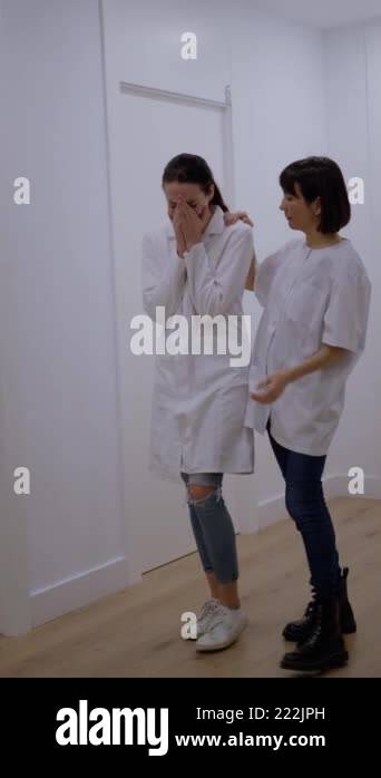 Medical professionals sharing compassionate moment, embracing with ...