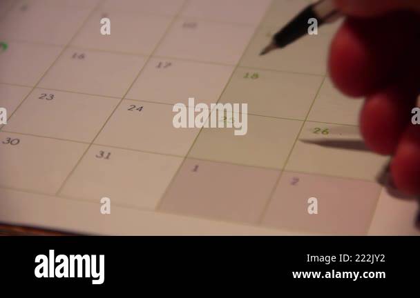 Young Man Writing on Calendar in Low Light at Home - 4K Resolution ...