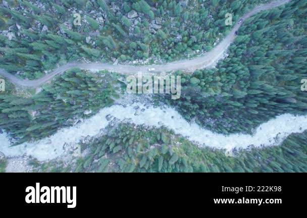 Aerial view from a drone of a river in the forest with a road on which ...