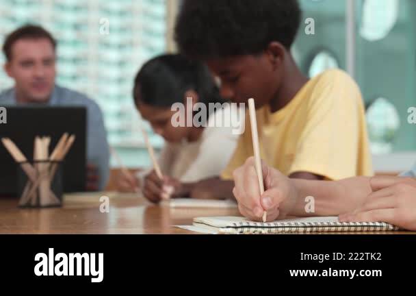 Closeup of student hand taking a note while girl ask teacher a question ...