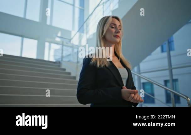 Woman executive smiling in camera standing at indoors staircase closeup ...