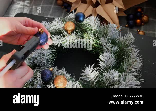 Crafter using hot glue Handmade Christmas wreath from festive blue and ...