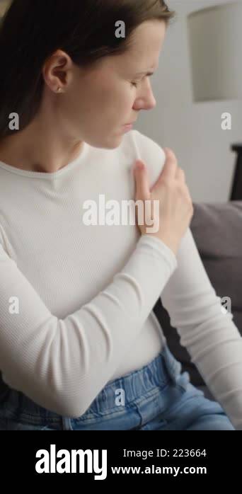 Vertical footage of tired unhappy young woman massaging hurt stiff neck ...