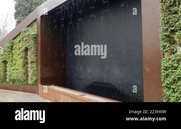 A stunning water wall amidst lush greenery, perfect for serene ...