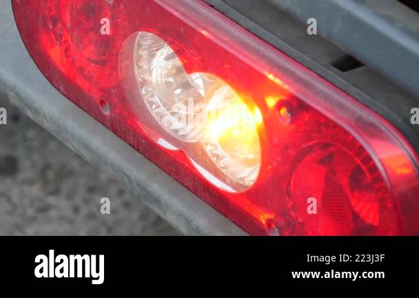 A detailed view of a cars bright red tail light showcasing an active ...