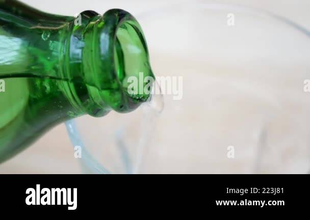 A refreshing and bubbly sparkling water is elegantly being poured into a clear glass Stock Video ...