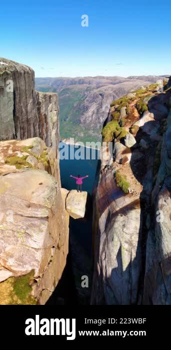 Experience a thrilling moment as a daring women adventurer balances on ...