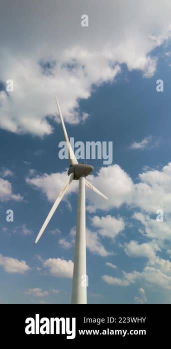 Majestic wind turbines tower against the backdrop of a vibrant blue sky dotted with fluffy ...