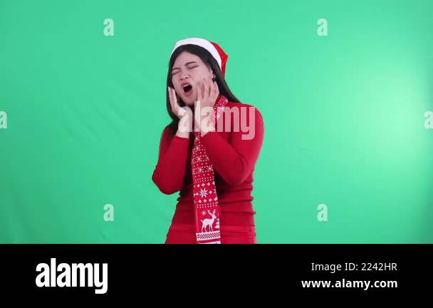 woman wearing Christmas sweater, Santa hat and scarf with grimacing ...