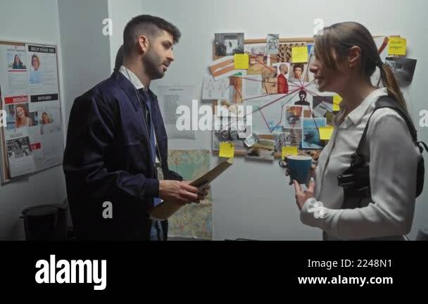 A man and woman detective analyze clues on a board in a police ...